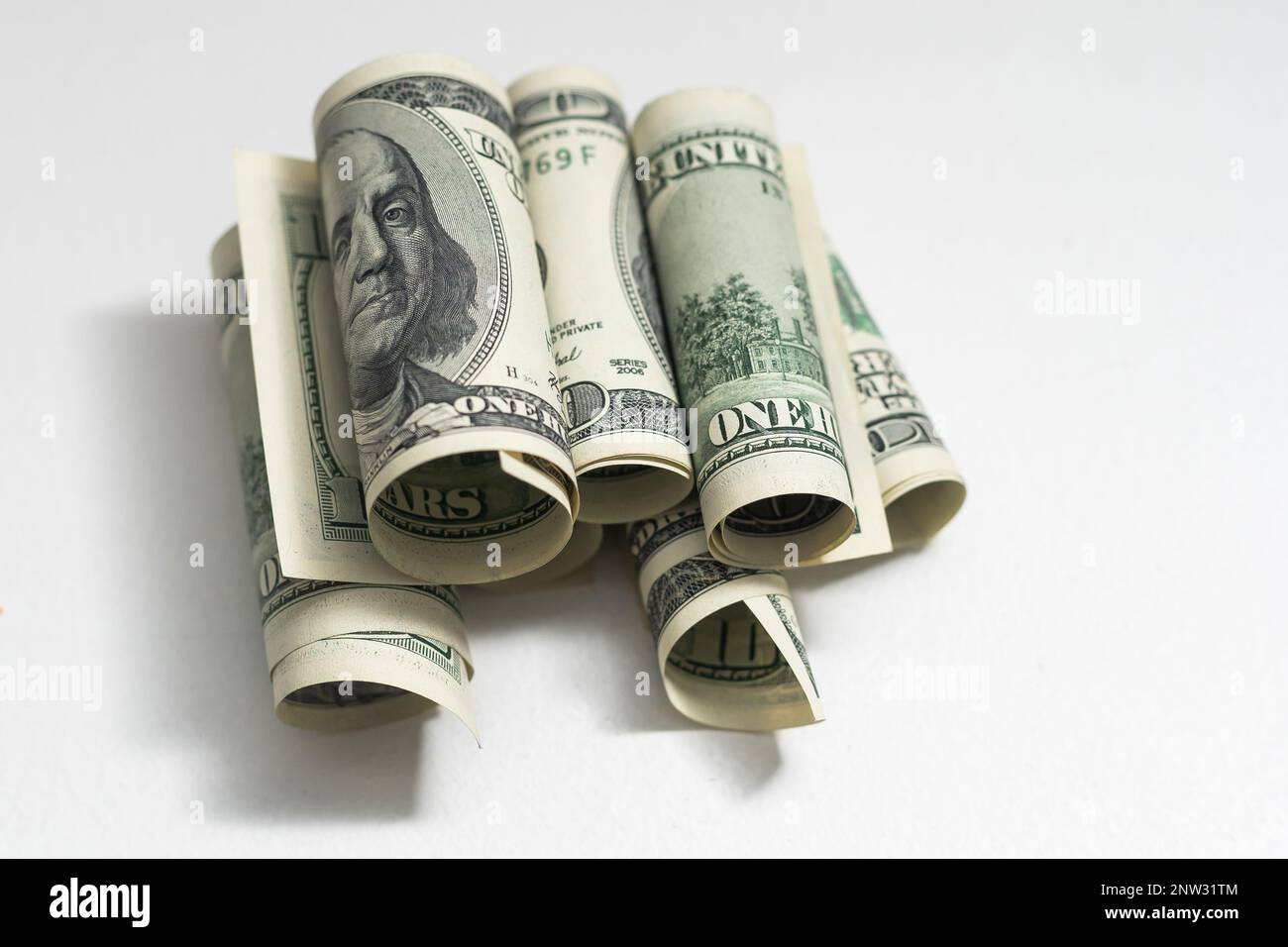 roles dollar notes in front of white background Stock Photo - Alamy