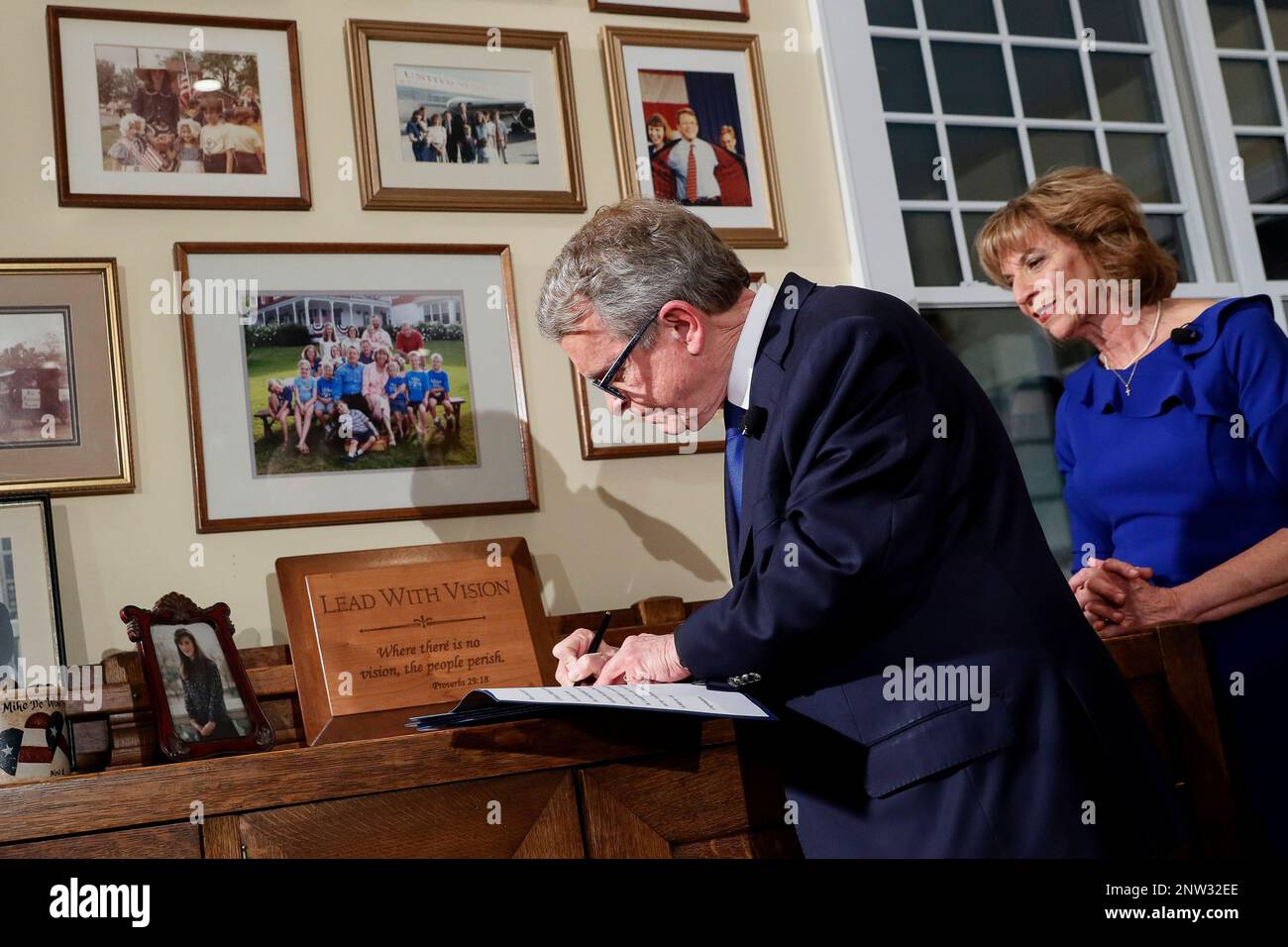 Ohio Gov. Mike DeWine signs his oath of office alongside his wife Fran ...