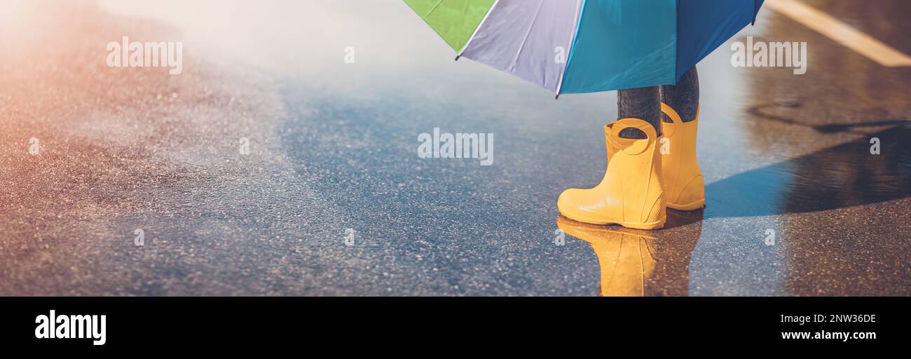 Child standing in the puddle in yellow rubber boots Stock Photo - Alamy