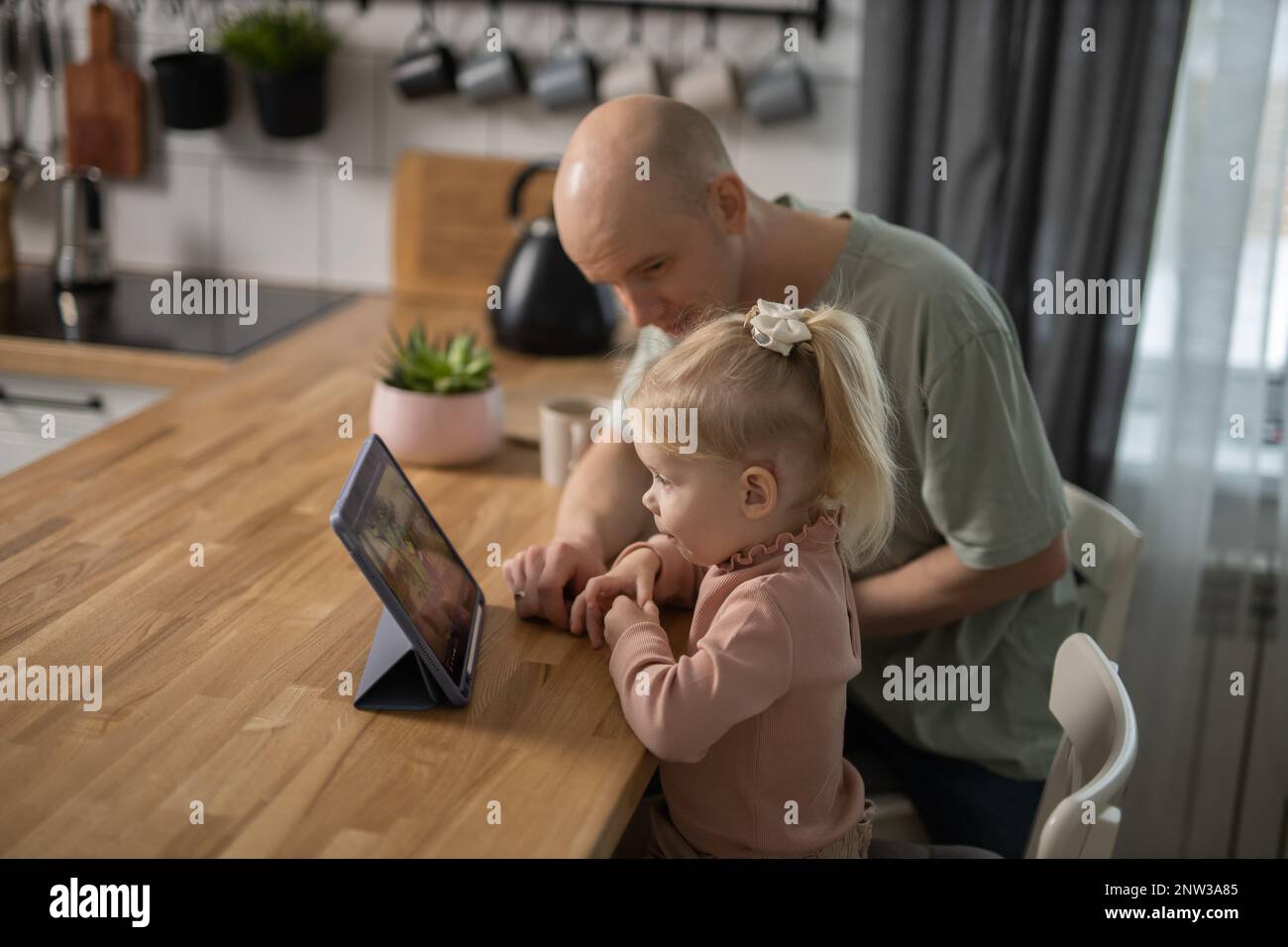 People with cochlear implant system. Kid study to hear with her father ...