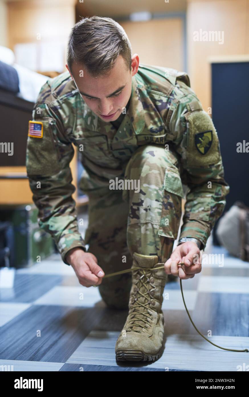 Brave is the man who wears combat boots. Shot of a young soldier tying ...
