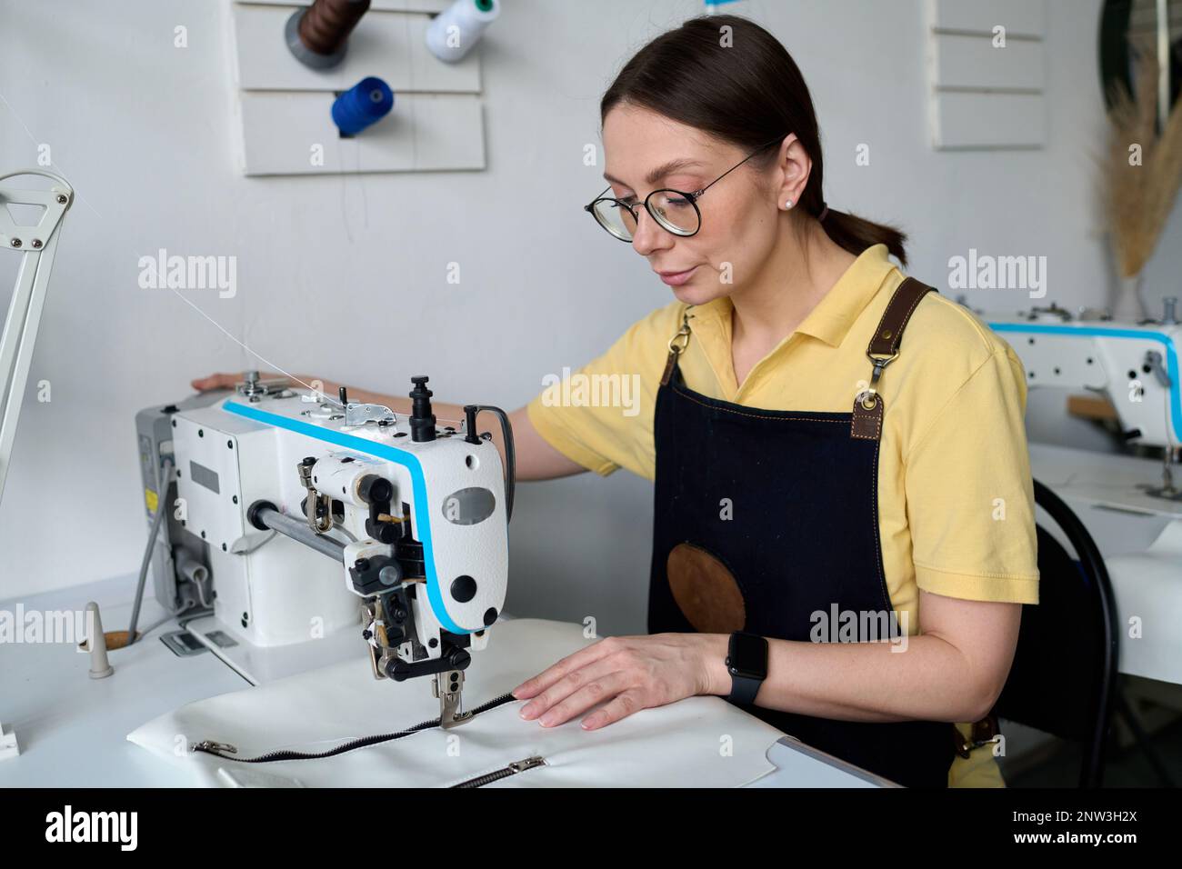 Professional female tanner creating new leather attire while sitting by ...