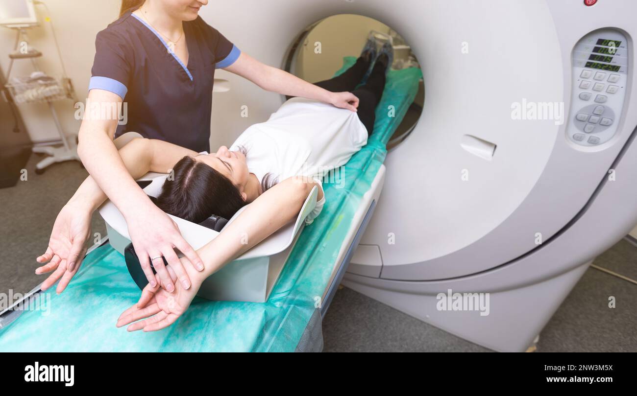 A woman lies on the tomograph table. woman is undergoing computed axial ...
