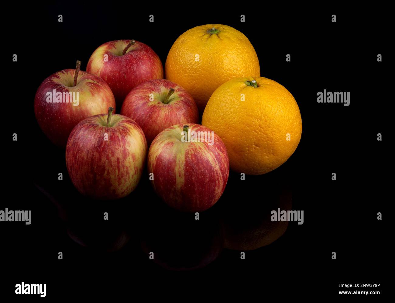 Apples and oranges together on a shiny black table top Stock Photo - Alamy