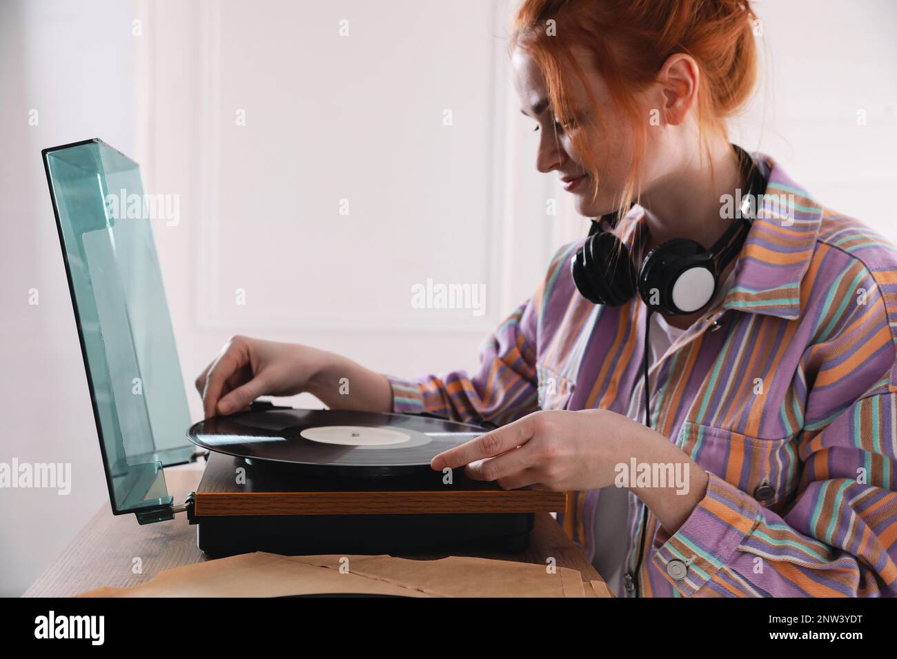 Beautiful young woman using turntable at home Stock Photo - Alamy