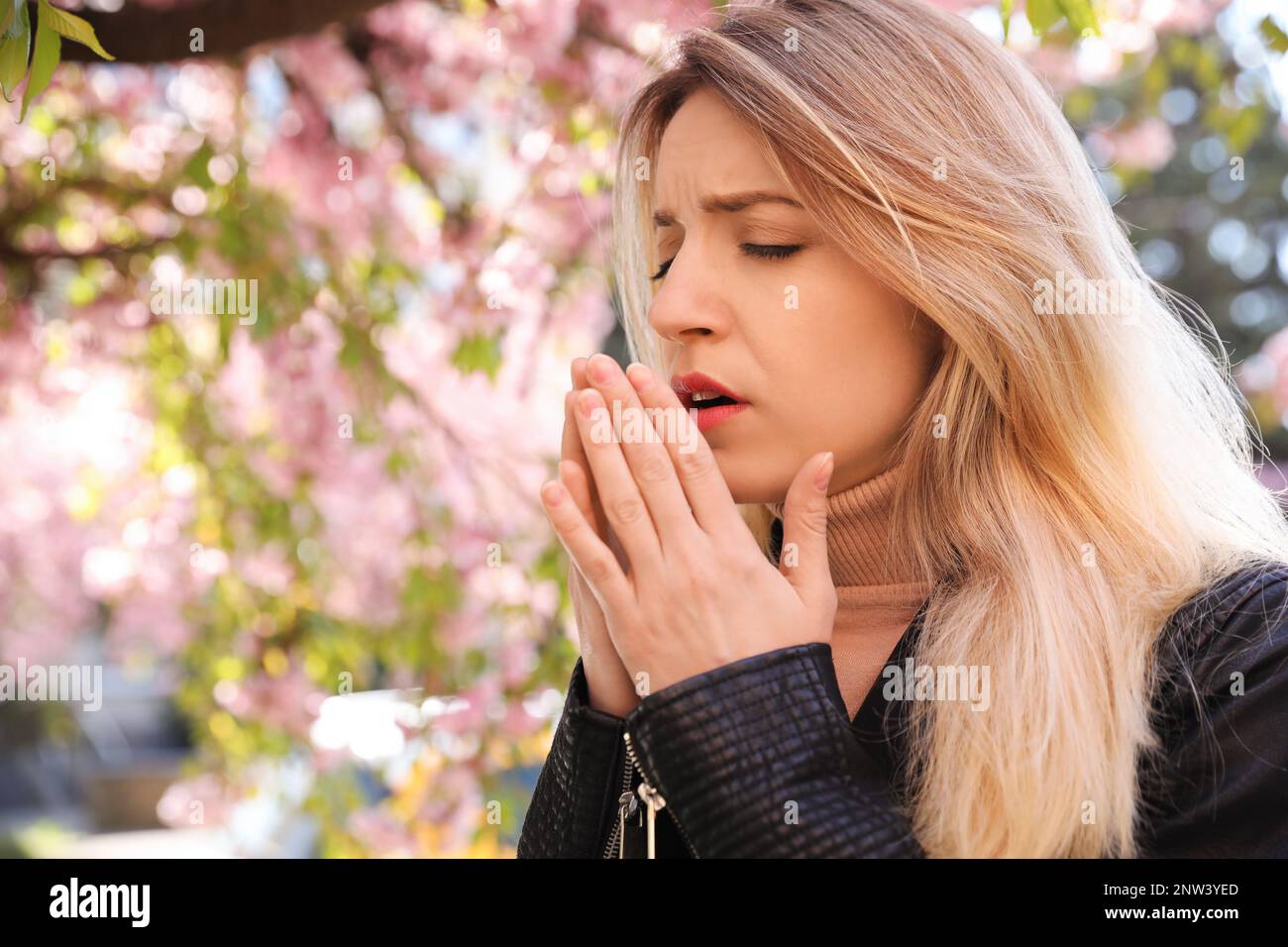 Woman suffering from seasonal pollen allergy near blossoming tree outdoors Stock Photo - Alamy
