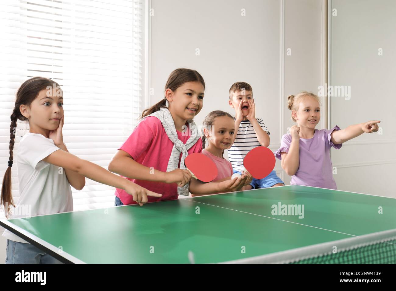 Cute happy children playing ping pong indoors Stock Photo - Alamy