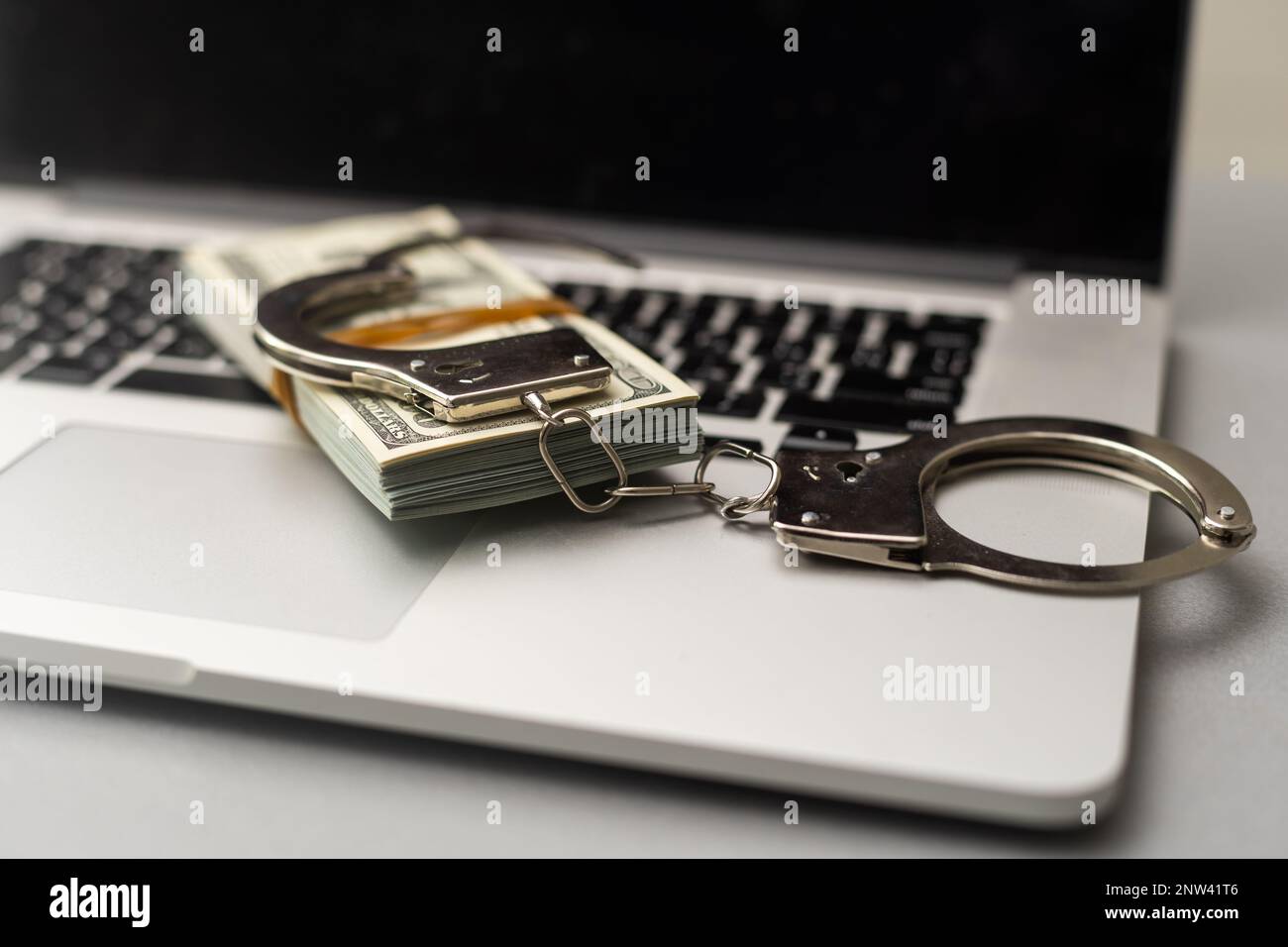 Cyber crime legal law police handcuffs on a hundred dollar bills with ...