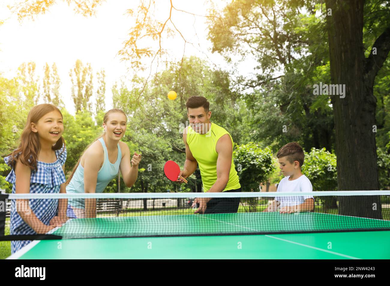 Happy family playing ping pong in park Stock Photo - Alamy
