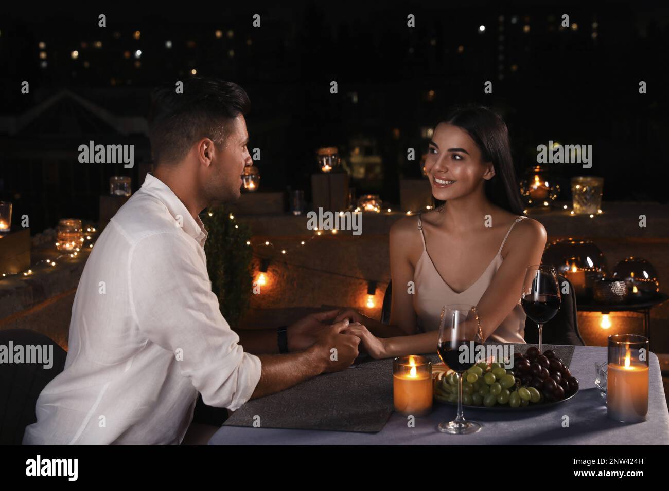 Romantic couple on cafe terrace at night Stock Photo - Alamy
