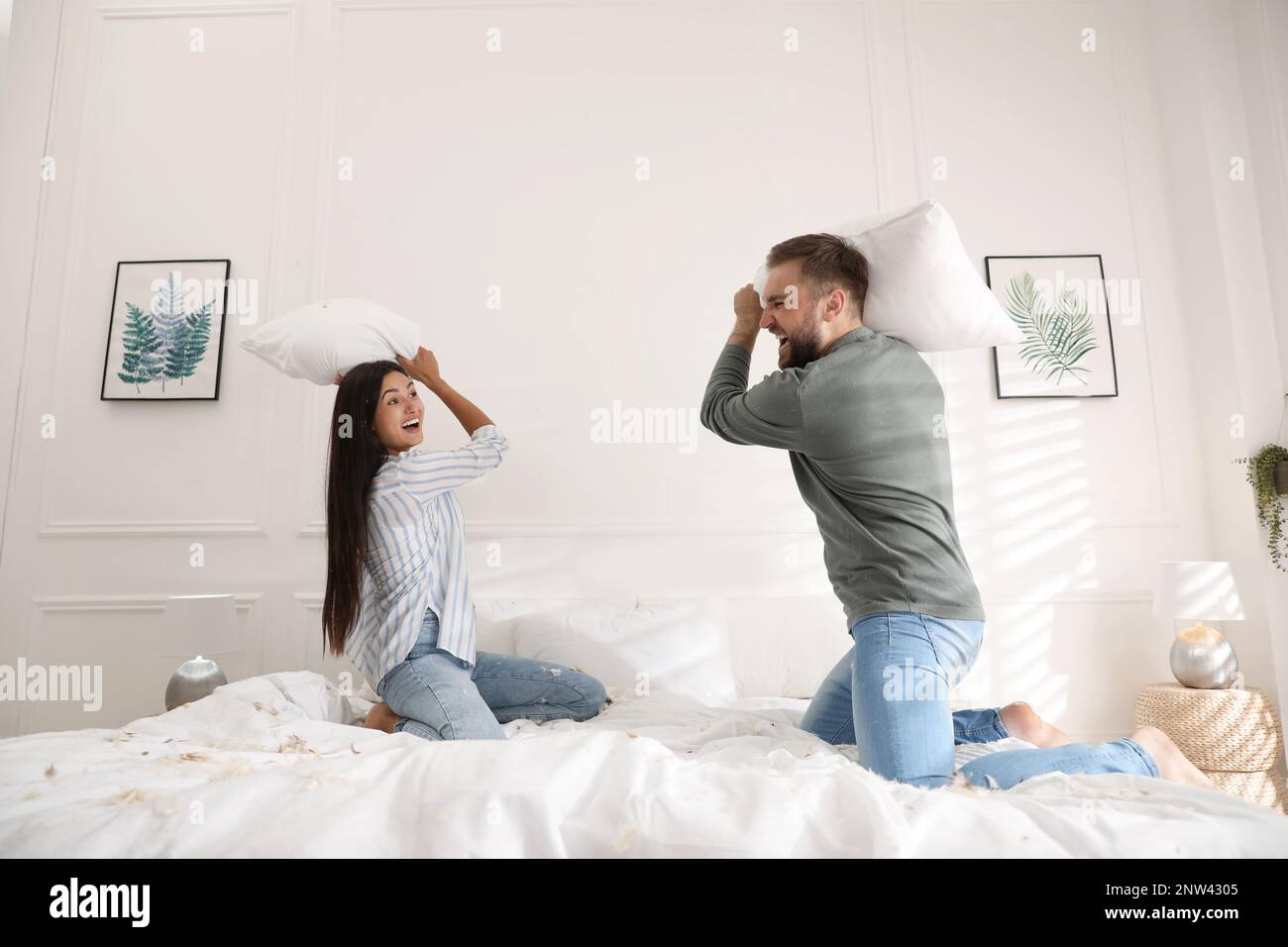 Happy young couple having fun pillow fight in bedroom Stock Photo - Alamy