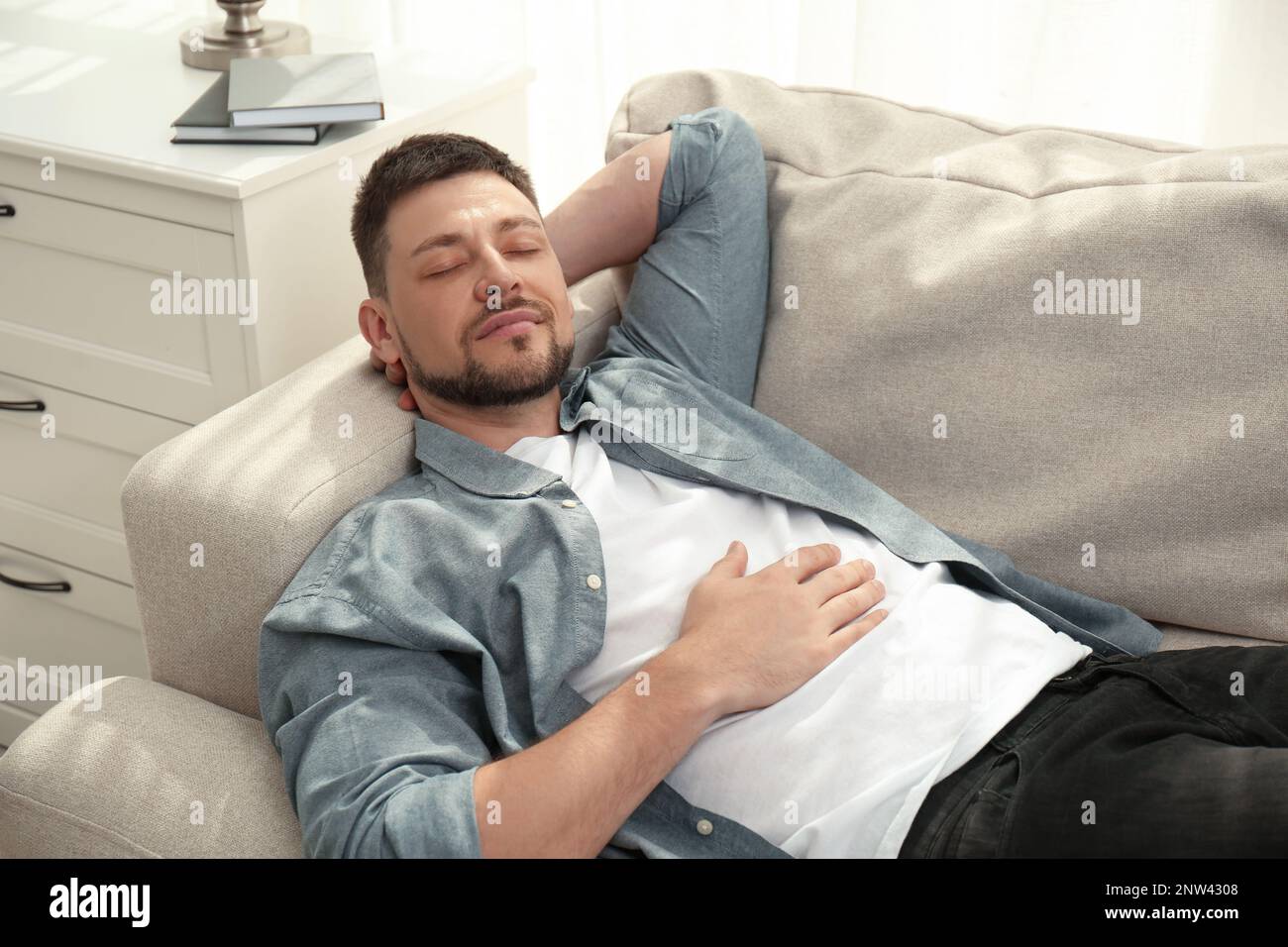 Handsome man sleeping on sofa at home Stock Photo - Alamy