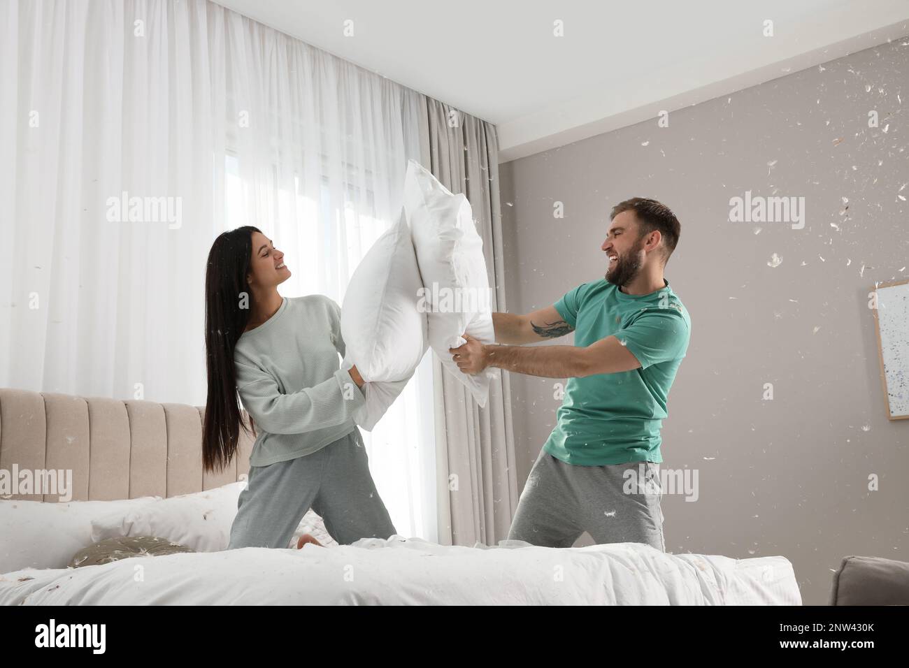 Happy young couple having fun pillow fight in bedroom Stock Photo - Alamy