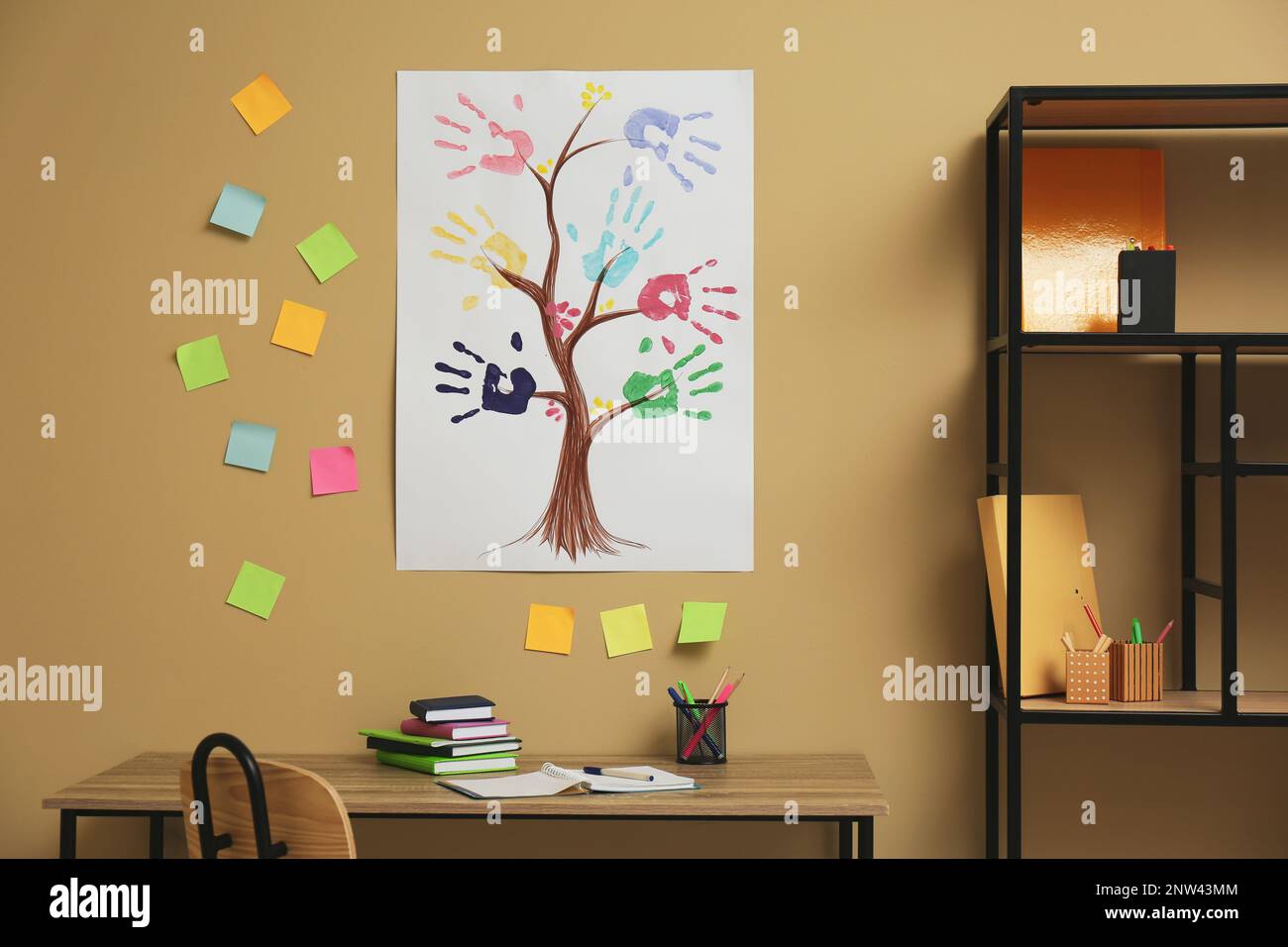 Painting with family tree of colorful palm prints on beige wall over ...