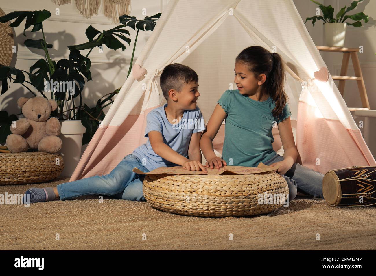Cute little children with treasure map near toy wigwam at home Stock ...
