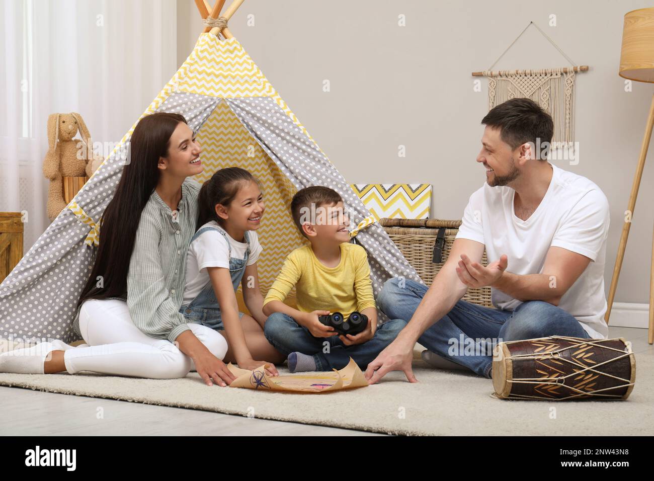 Happy family with treasure map near toy wigwam at home Stock Photo - Alamy