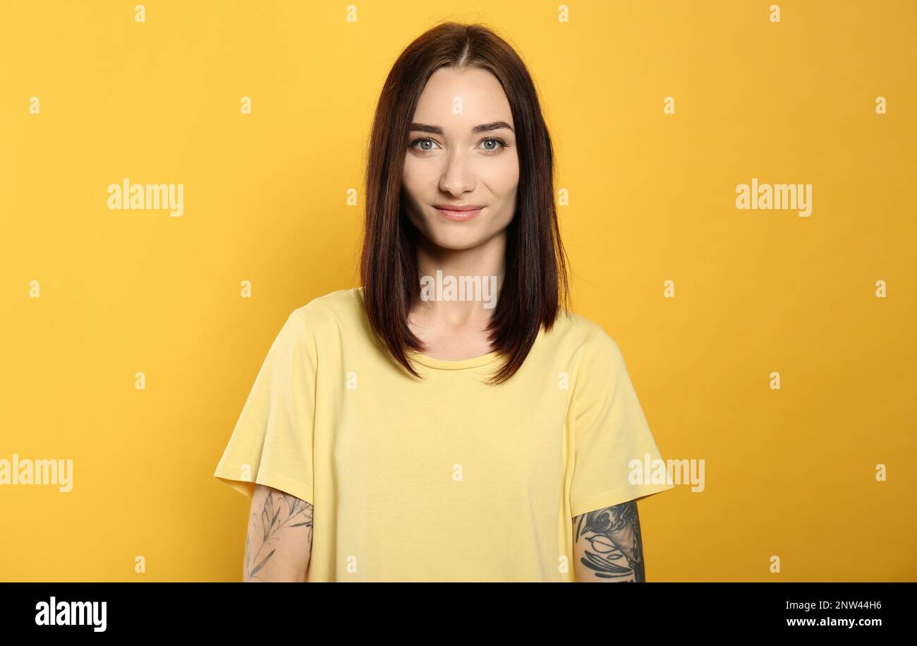 Portrait of pretty young woman with gorgeous chestnut hair on yellow ...