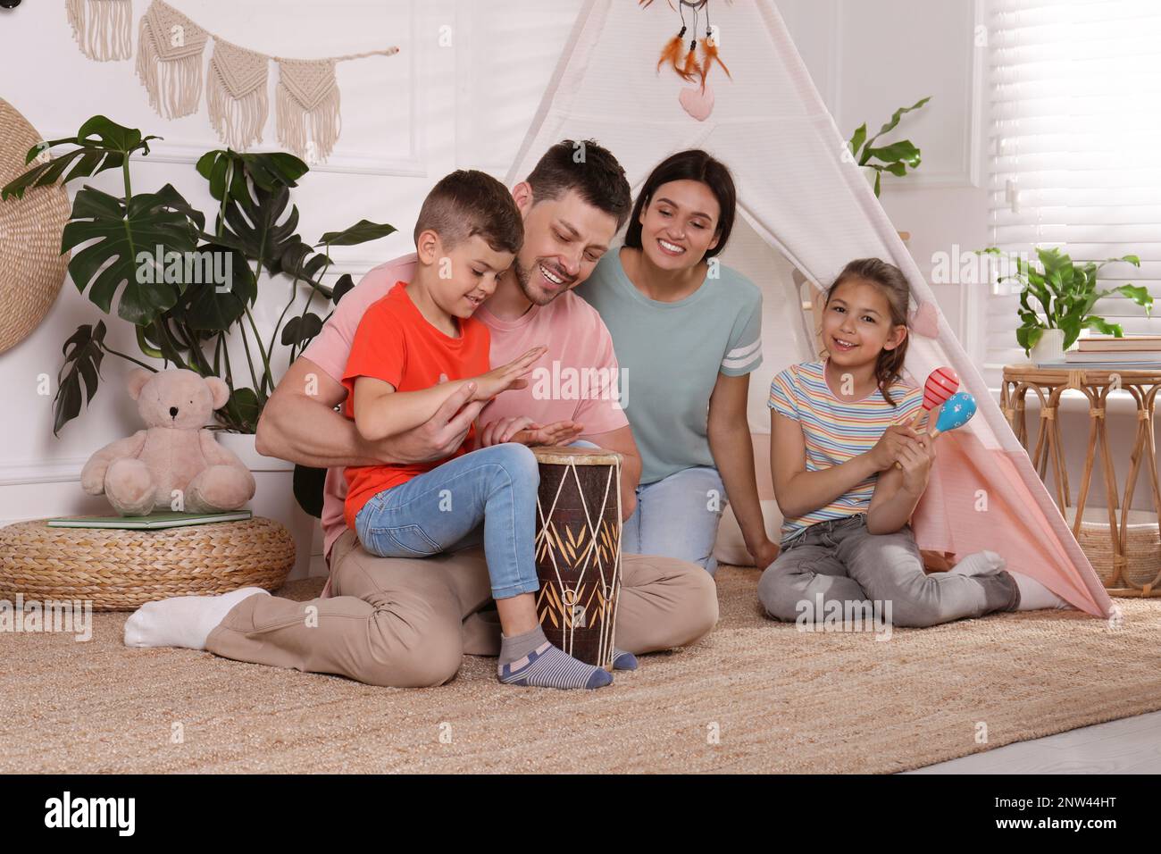 Happy family playing together near toy wigwam at home Stock Photo - Alamy