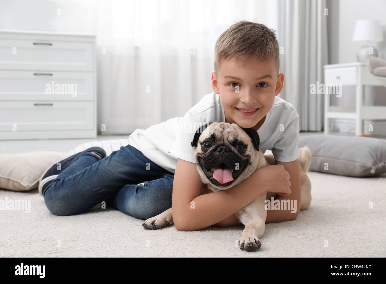 Boy with his cute pug on floor at home Stock Photo - Alamy