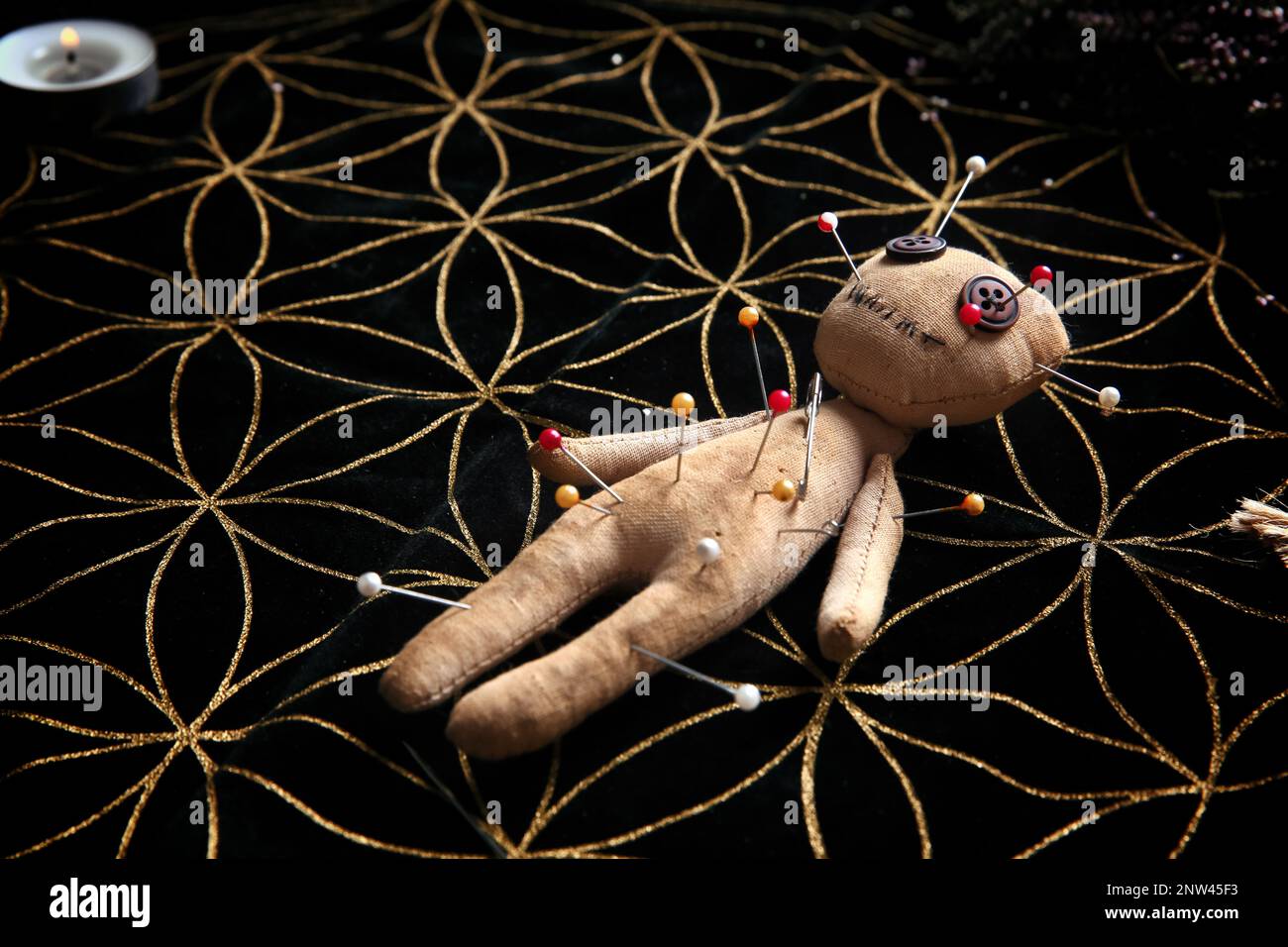 Voodoo doll pierced with pins on table. Curse ceremony Stock Photo - Alamy