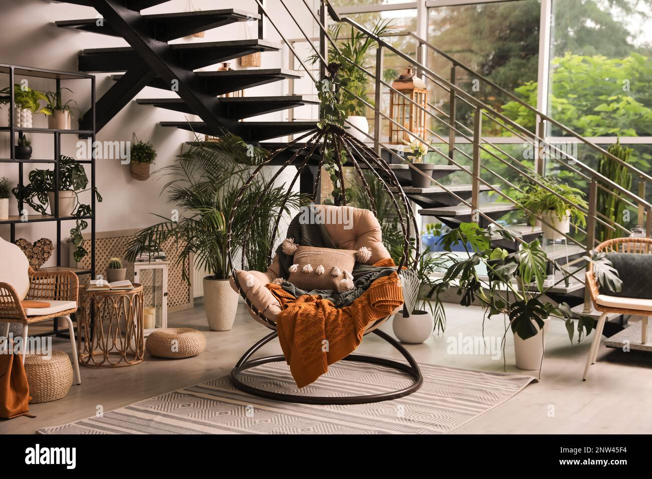 Indoor terrace interior with hanging chair and green plants Stock Photo ...
