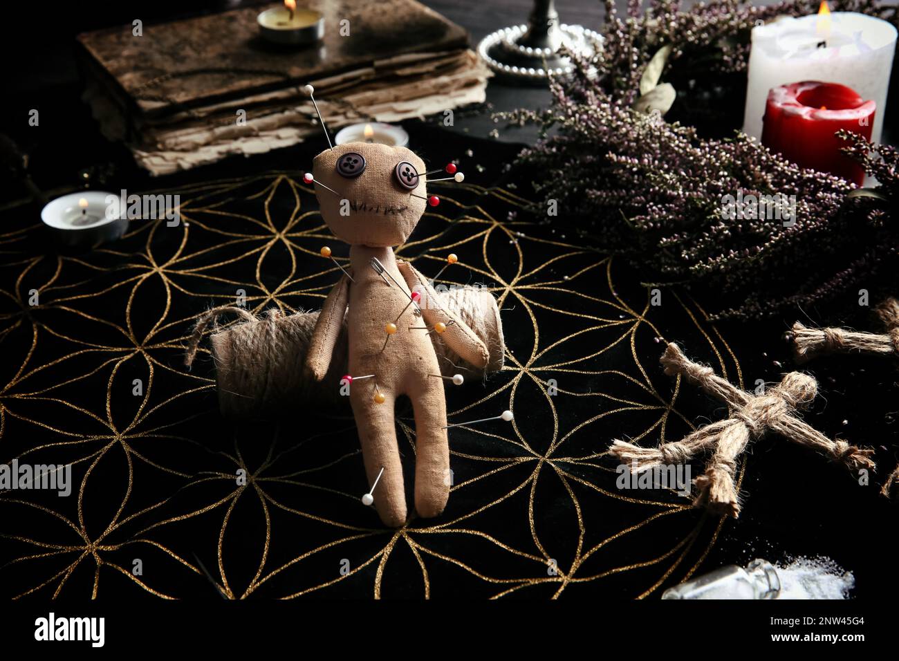 Voodoo doll pierced with pins on table. Curse ceremony Stock Photo - Alamy