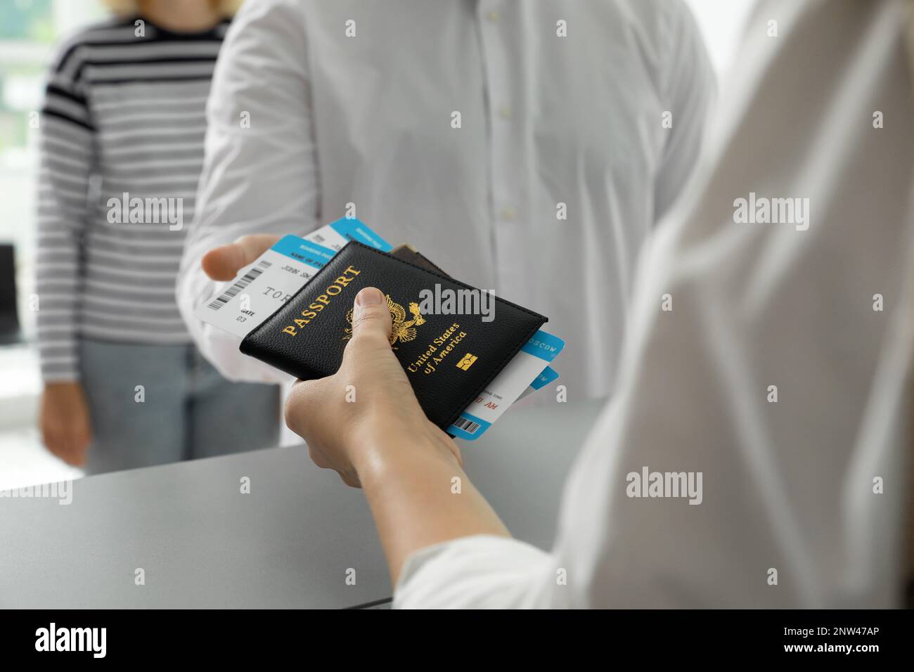 Agent giving passports and tickets to man at check-in desk in airport, closeup Stock Photo - Alamy