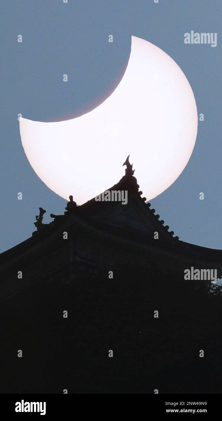 A composition photo shows a partial solar eclipse and the Gifu Castle ...