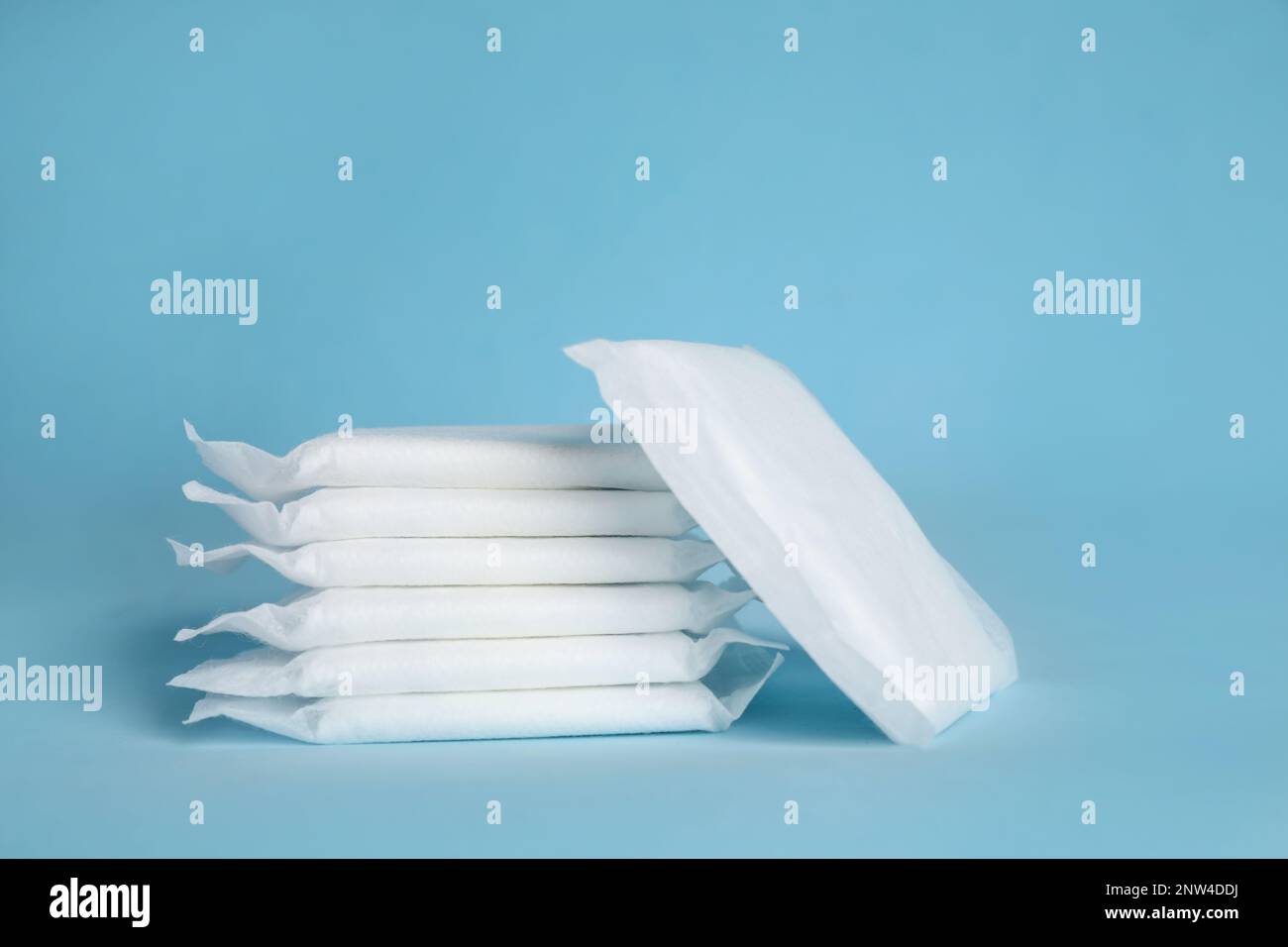 Stack of menstrual pads on light blue background Stock Photo - Alamy