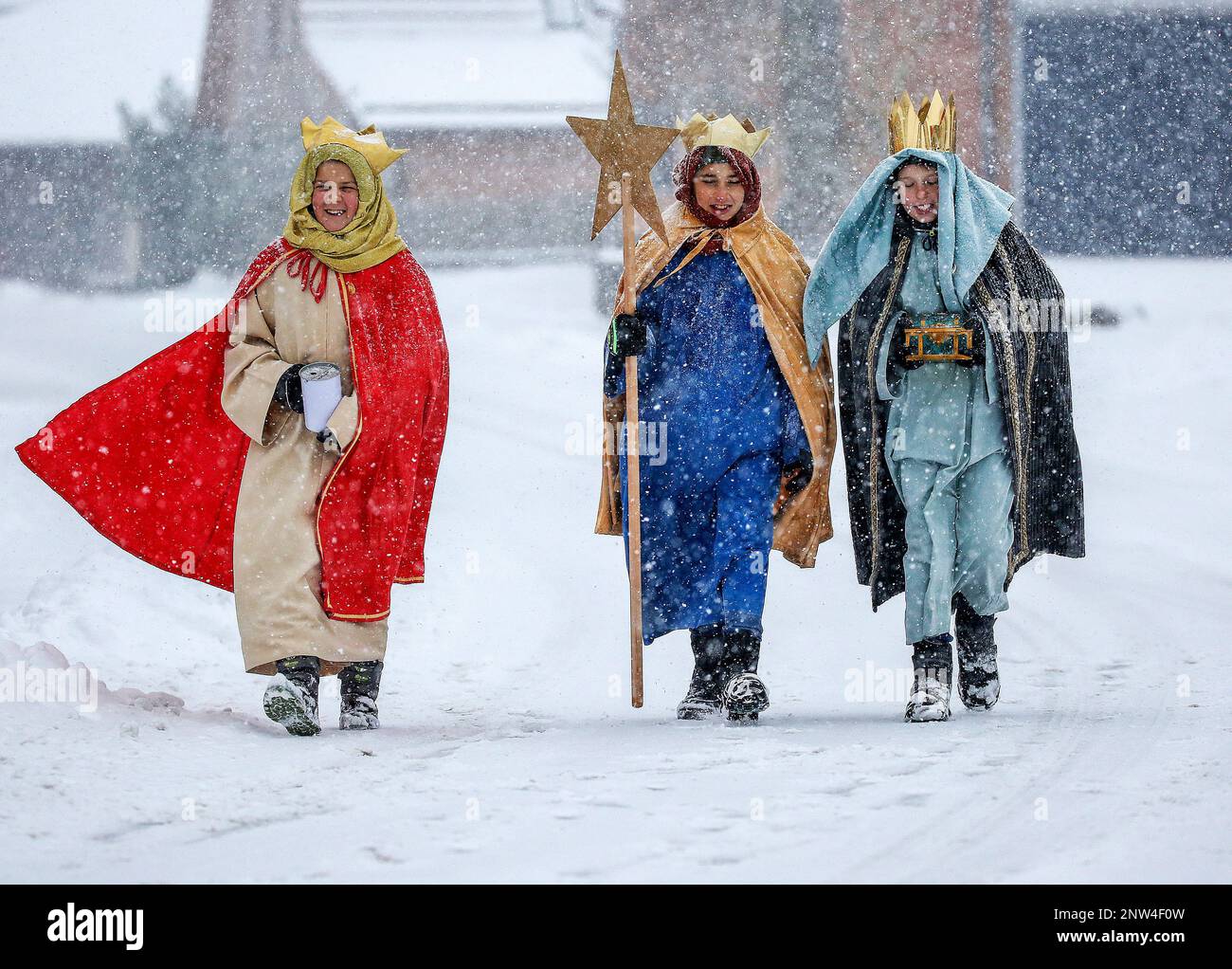 Coral singer in traditional costumes walk through the snow in Eglingen ...