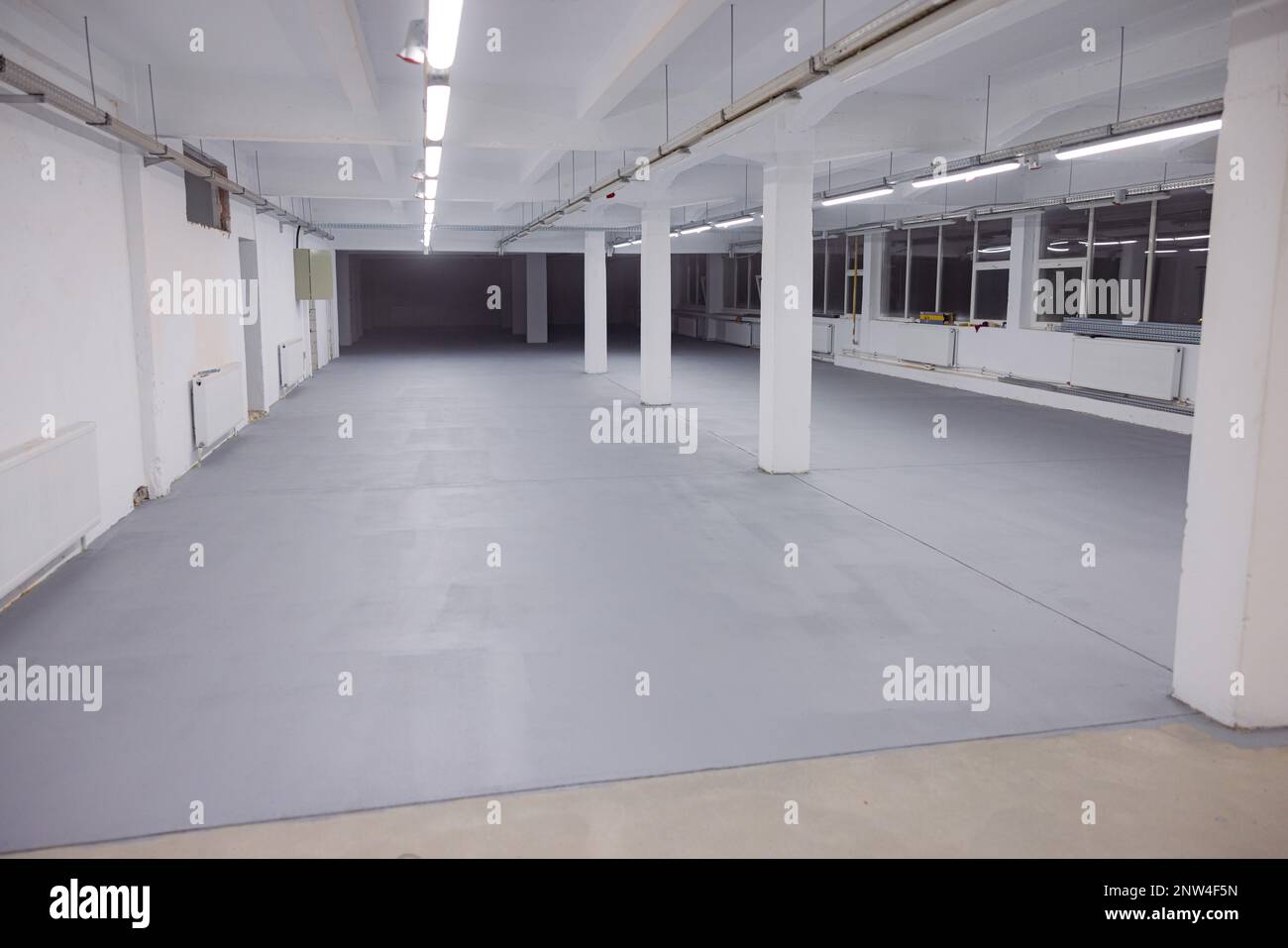 Production hall equipped with new gray epoxy flooring Stock Photo - Alamy