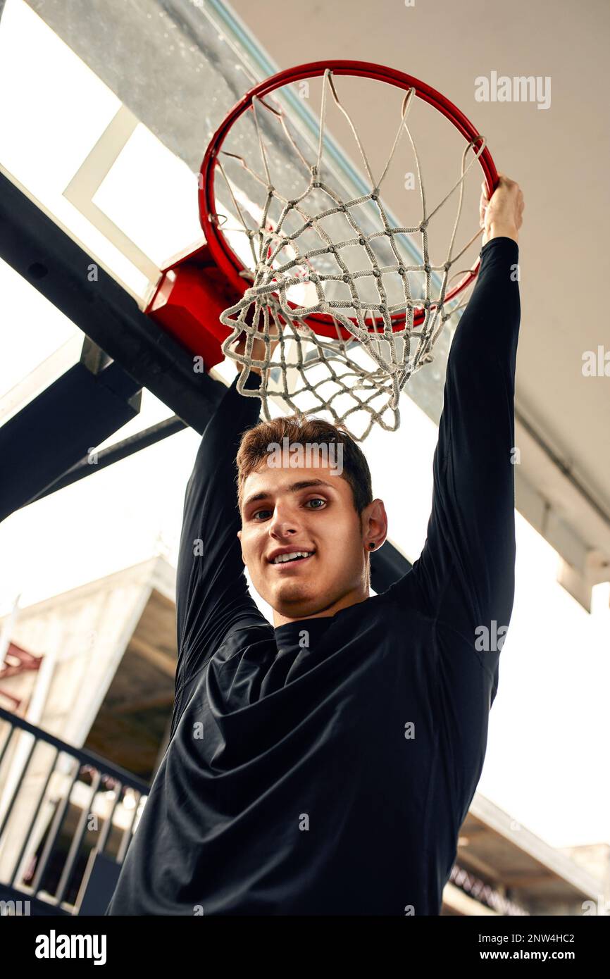 Basketball, sports and a man hanging on a hoop during a summer game ...