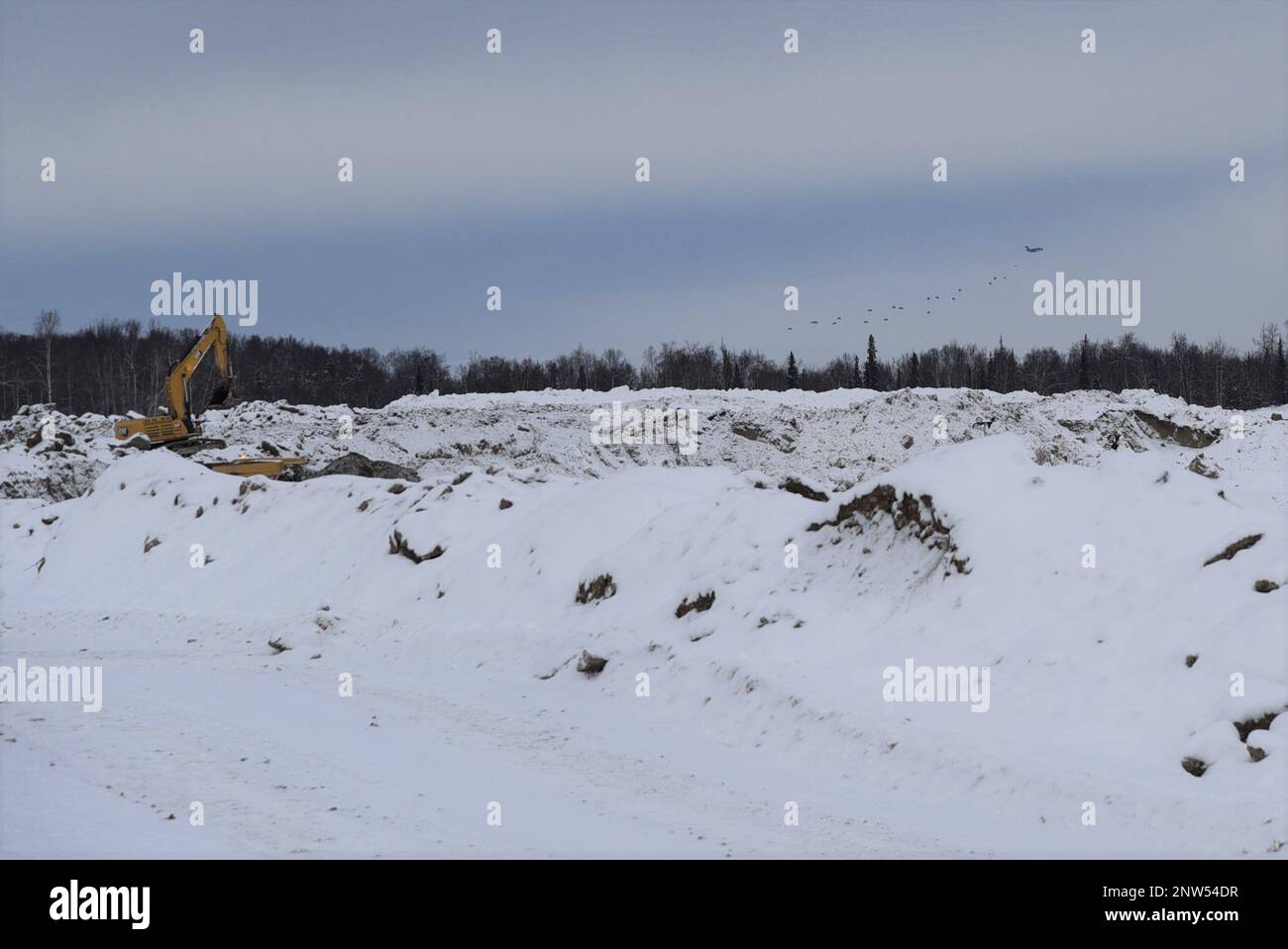 Paratroopers drop from a C-17 near the 16/34 runway extension project ...