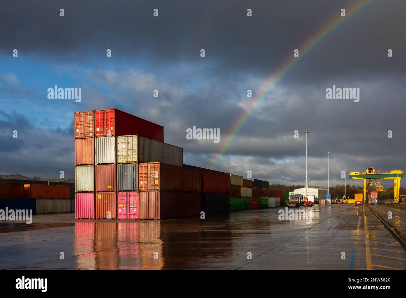 A stack of shipping containers on a deserted commercial dock with ...