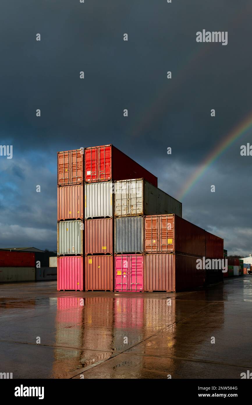 A stack of shipping containers on a deserted commercial dock with ...