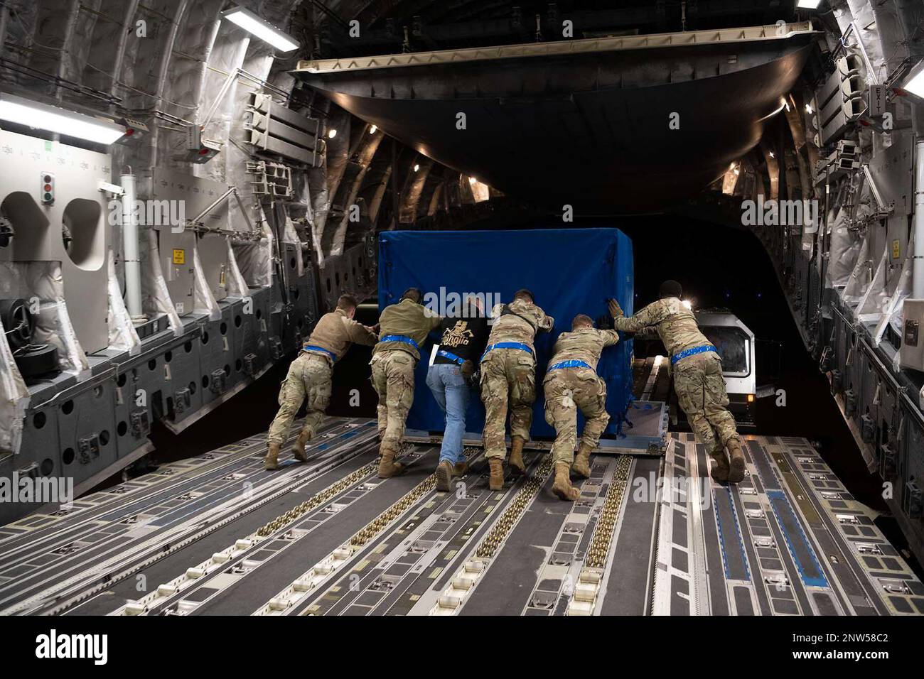 U.S. Airmen from the 60th Aerial Port Squadron push cargo onto a 60K ...