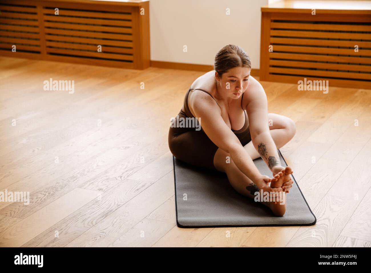 Ginger young woman doing exercise during yoga practice indoors Stock ...