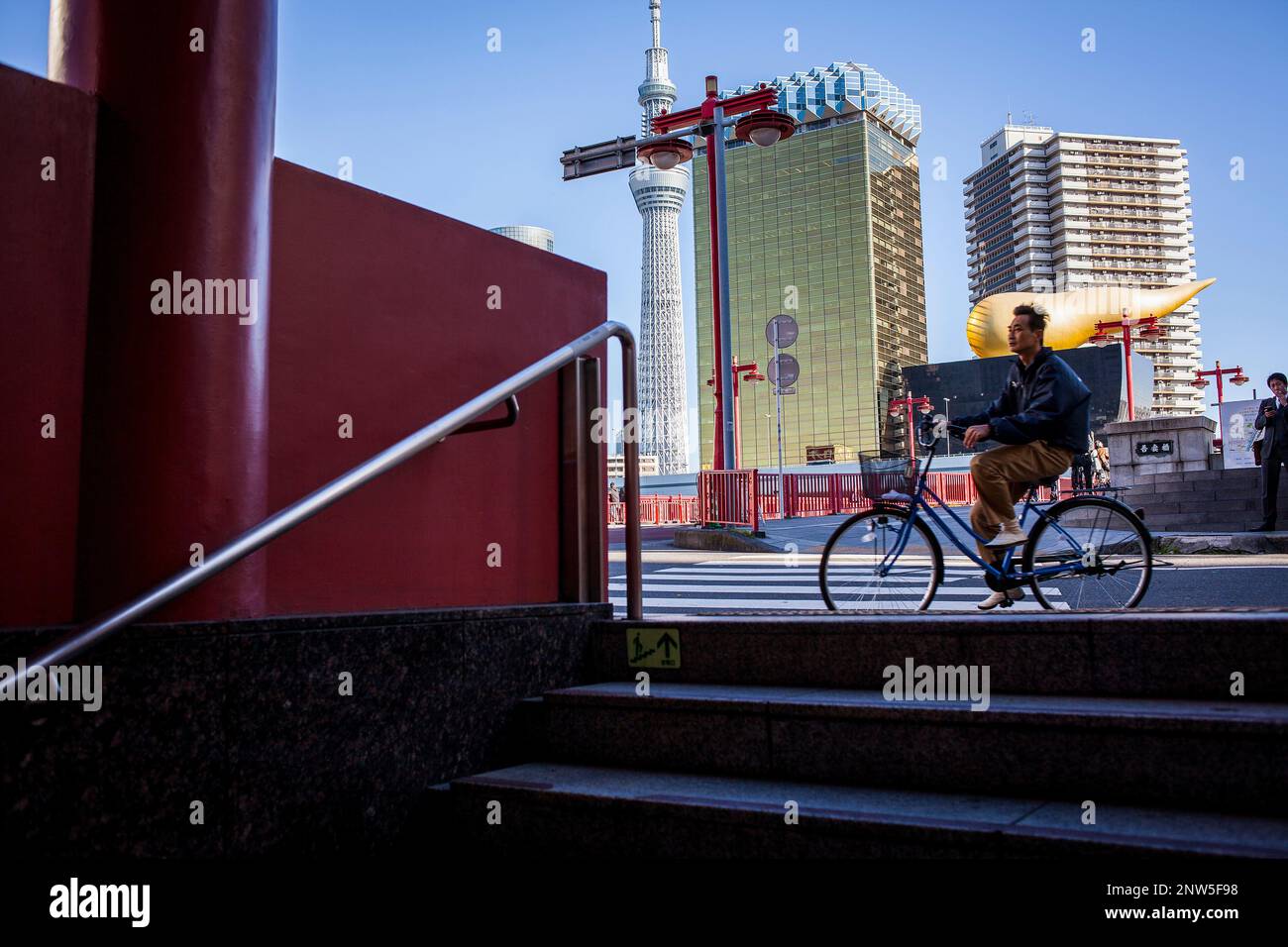 Cyclist. In background Sky Tree, Asahi building and Azuma bridge, from ...
