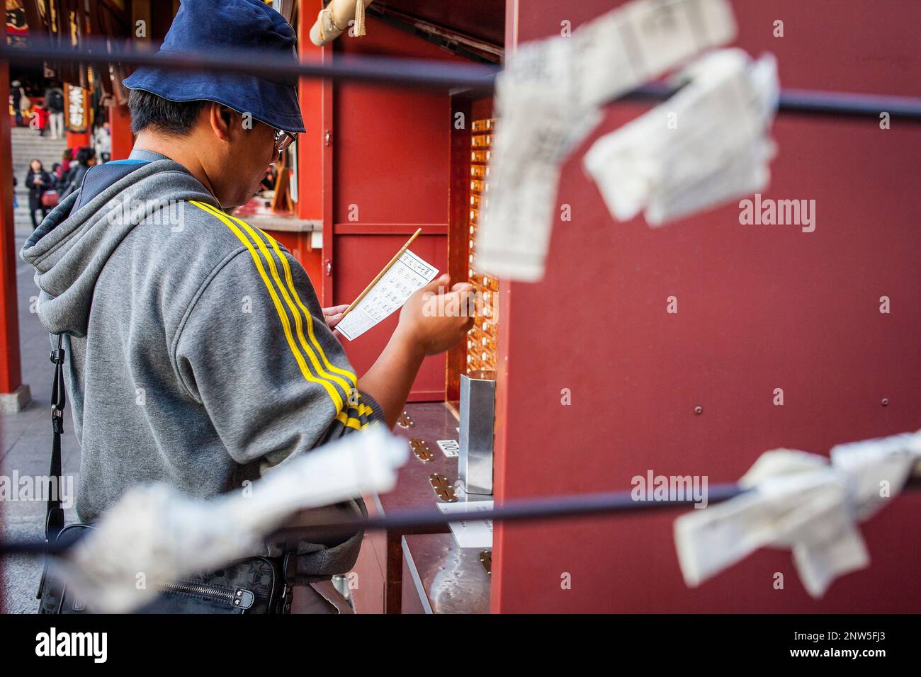 Boy reads a Omikuji fortune telling papers. Senso-ji Temple, Asakusa ...