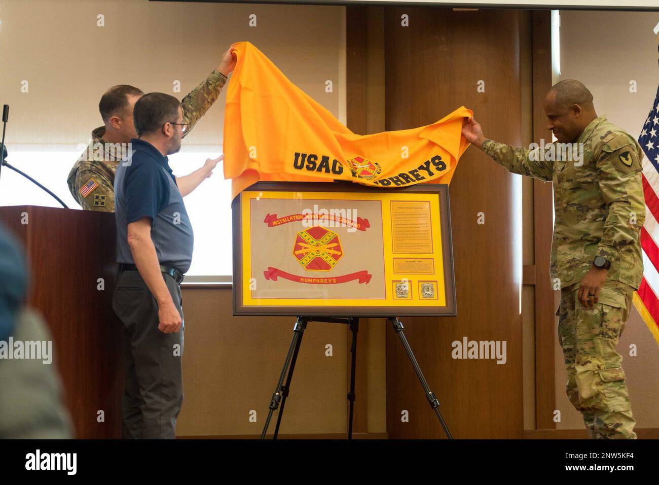 Command Sgt. Maj. Benjamin Lemon (right) unveils a farewell gift from ...