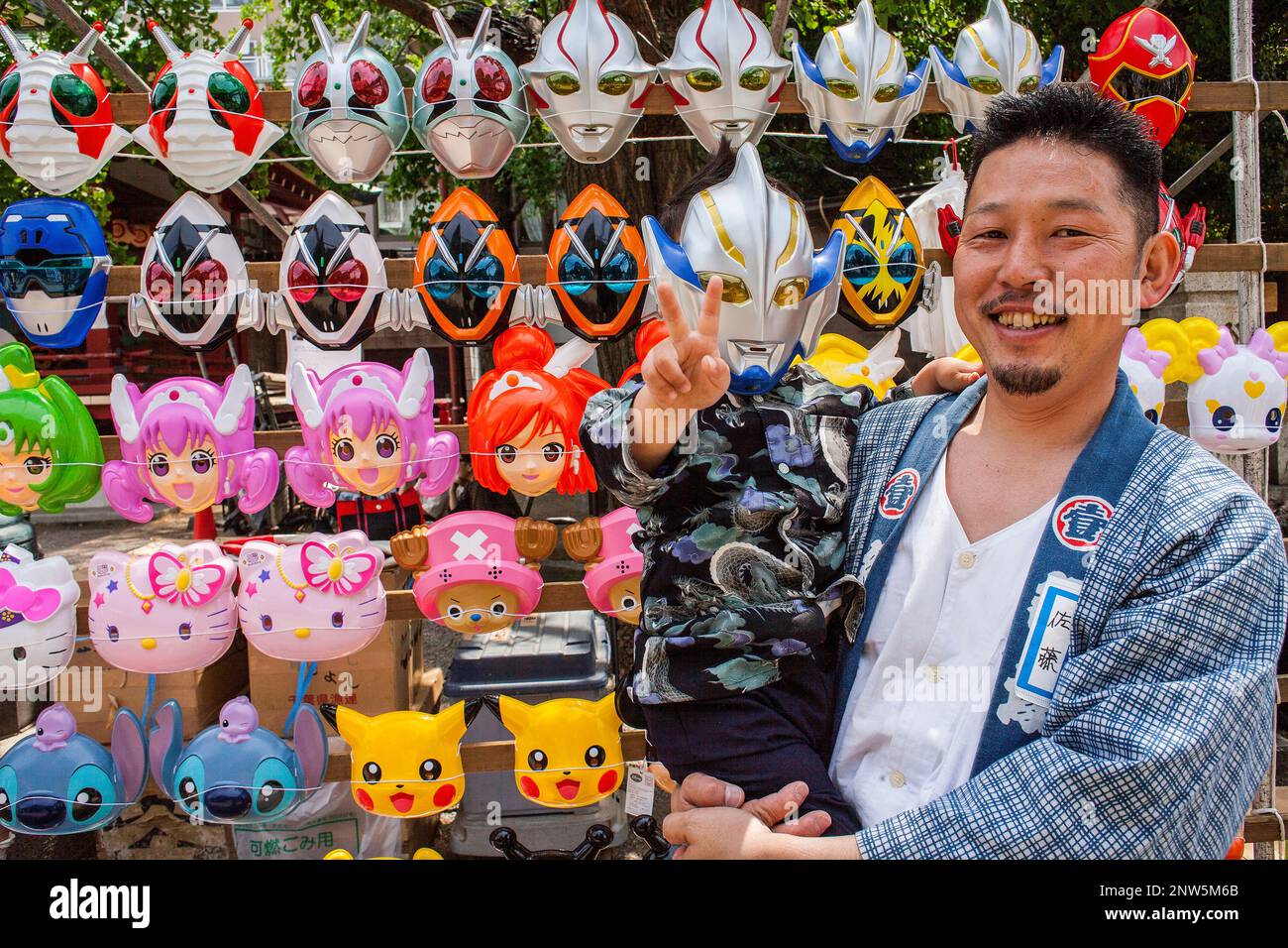Father and son next to a stall of masks, in Senso-ji Temple during ...