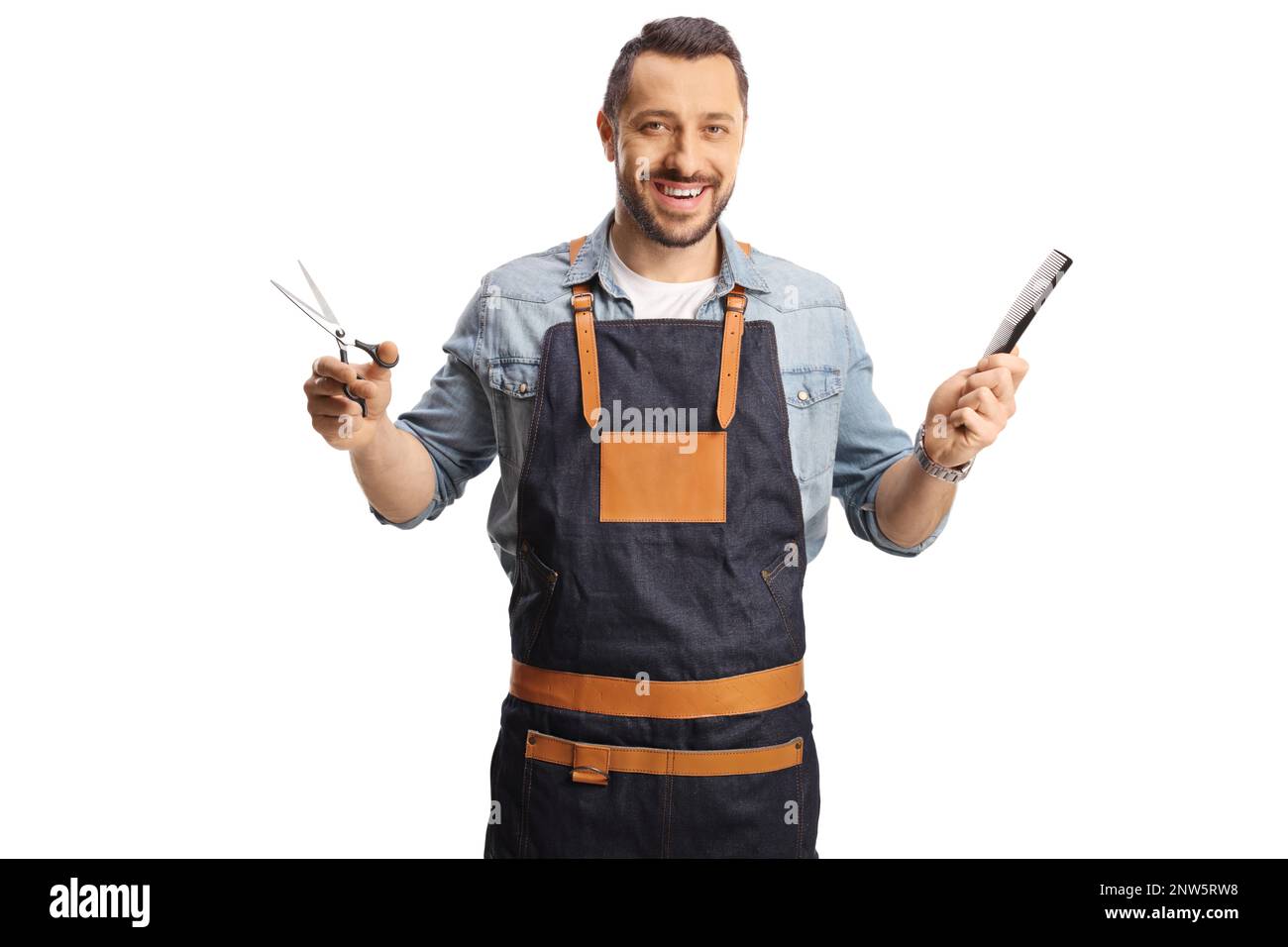 Man wearing an apron and holding a pair of scissors and a hair comb ...