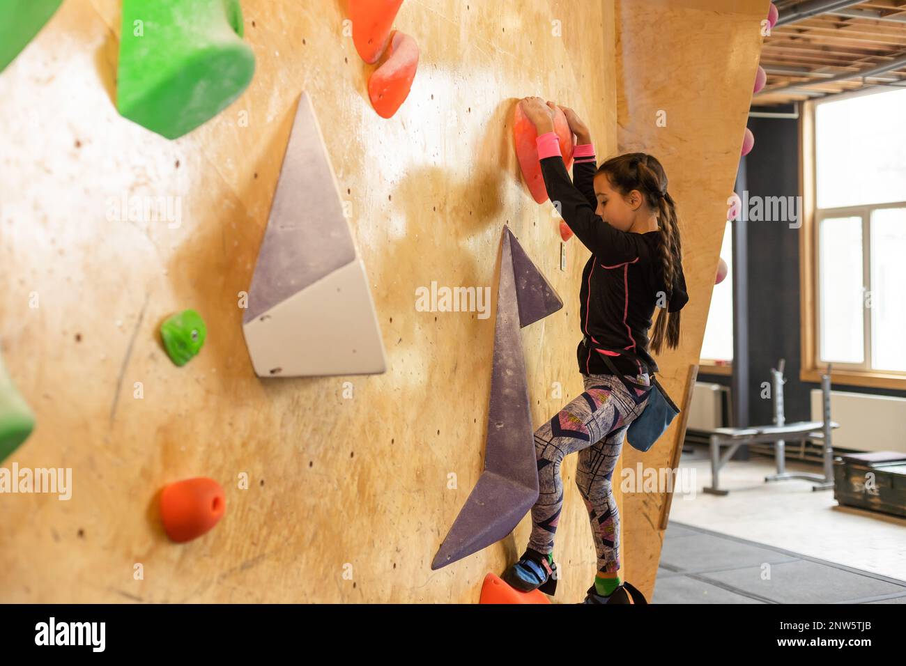 little girl climbing a rock wall indoor Stock Photo - Alamy