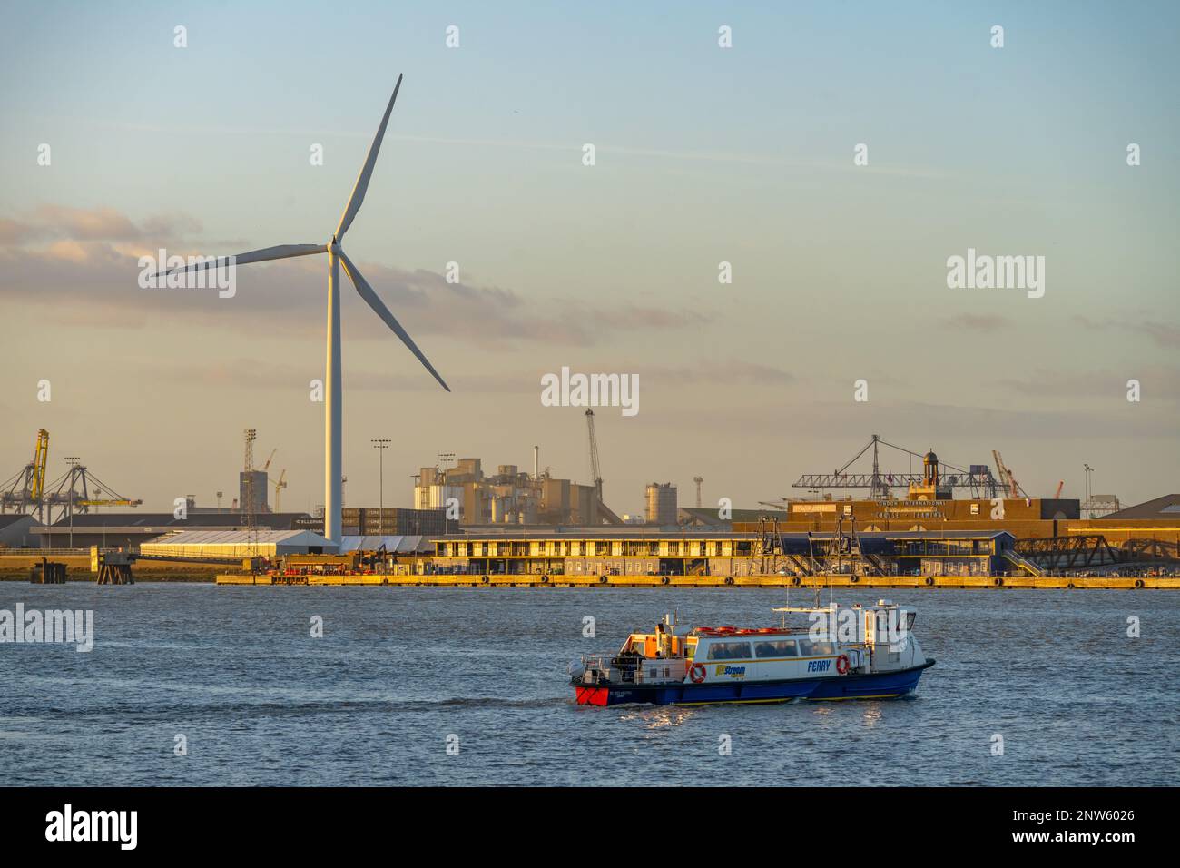 Wind turbine on Tilbury docks and the Tilbury ferry in the foreground ...