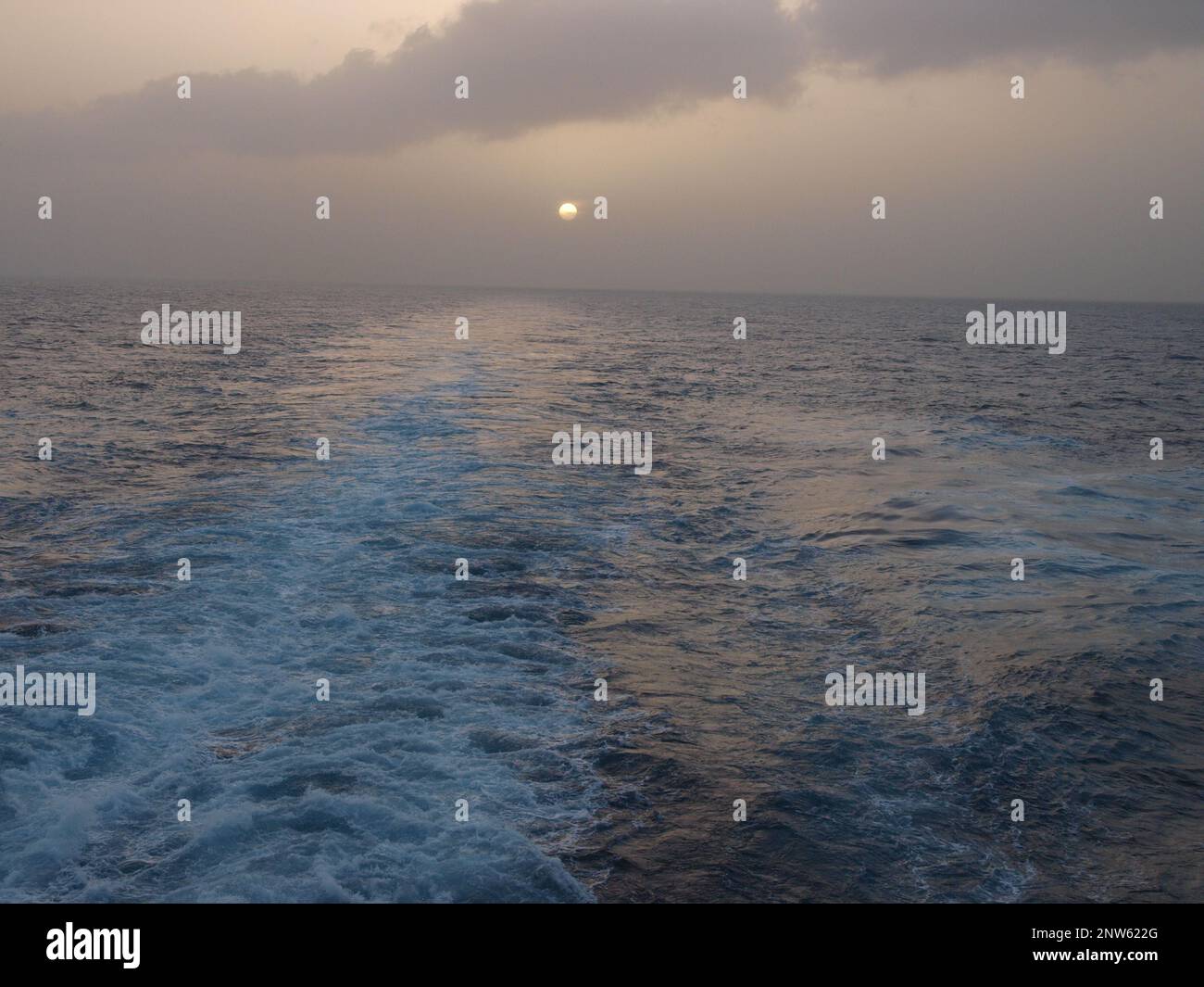Atlantic Ocean sunset over a cruise ship wake as the ship travels from ...