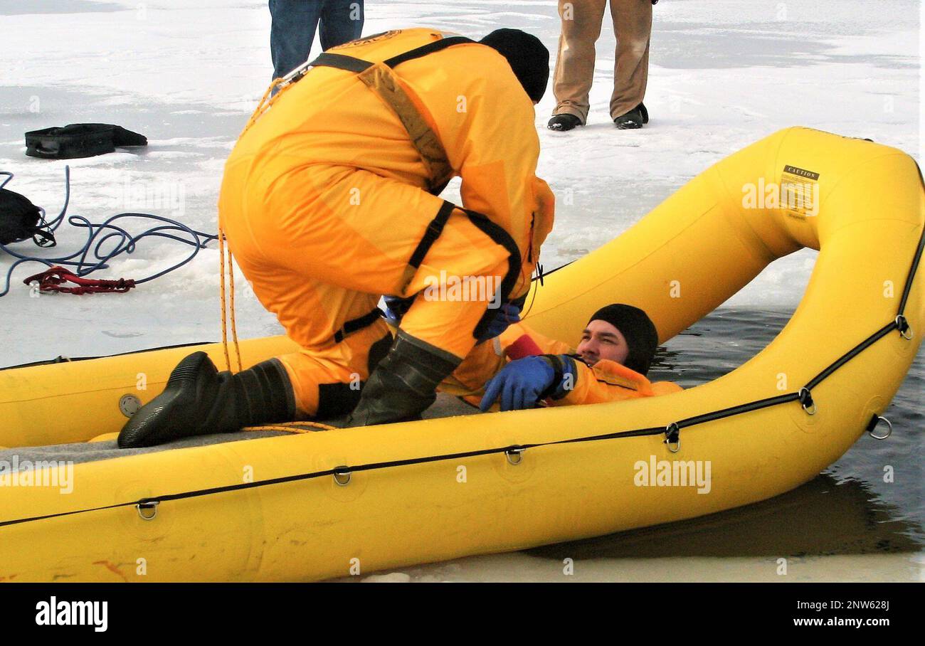 Firefighters wearing cold-water immersion protective suits hold surface ...