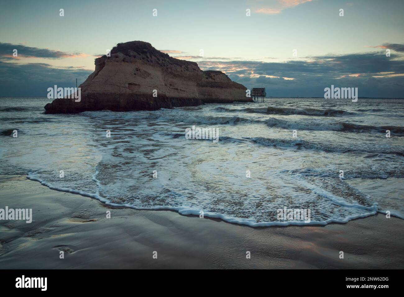 Sunset on beach and limestone sea rock on west Atlantic coast France ...