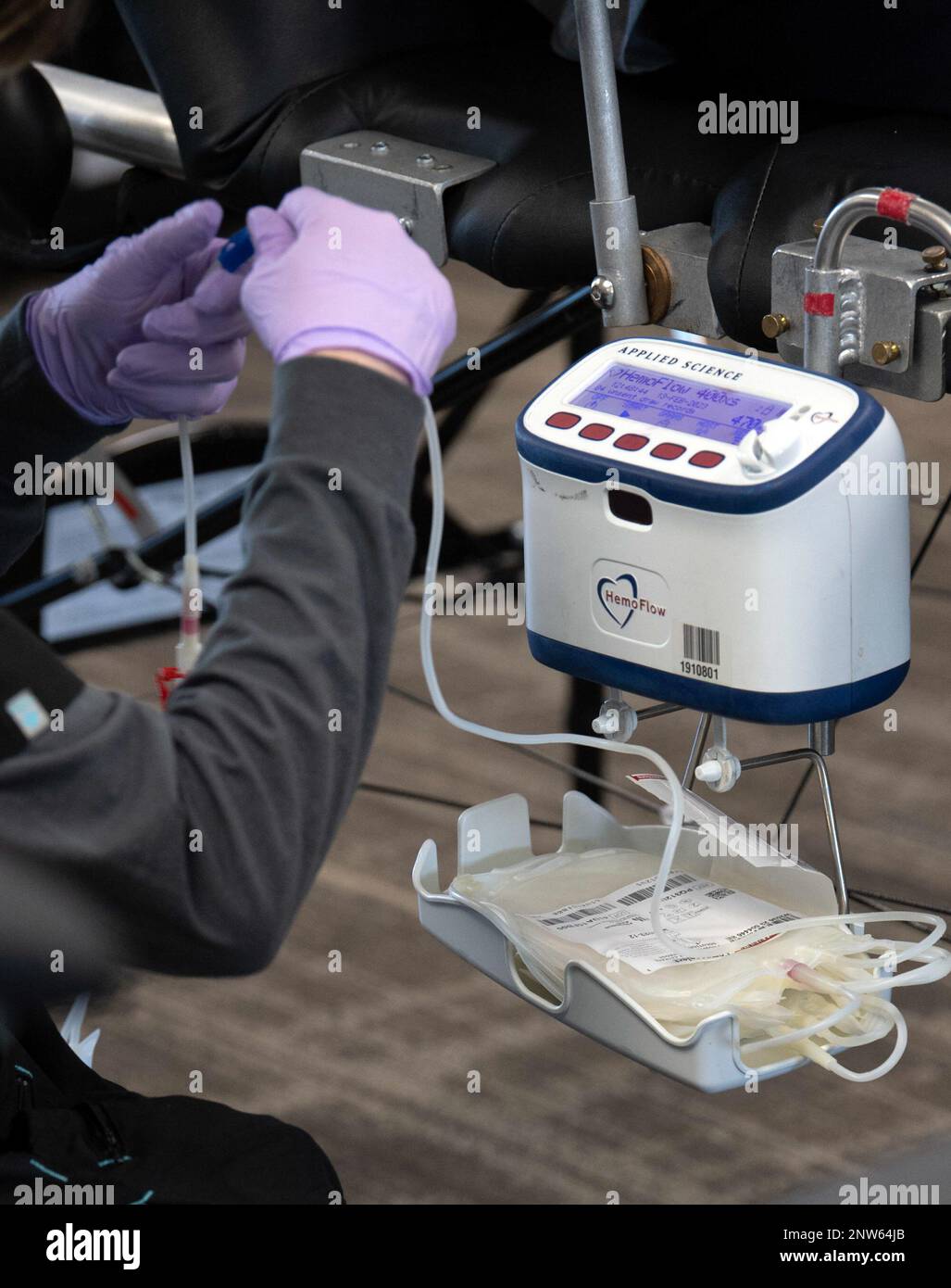 A Red Cross volunteer prepares a machine before taking a blood donation ...