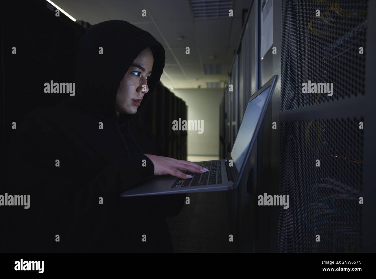 Hacker, server room and woman computer coding, data center crime and ransomware of cyberpunk in ...