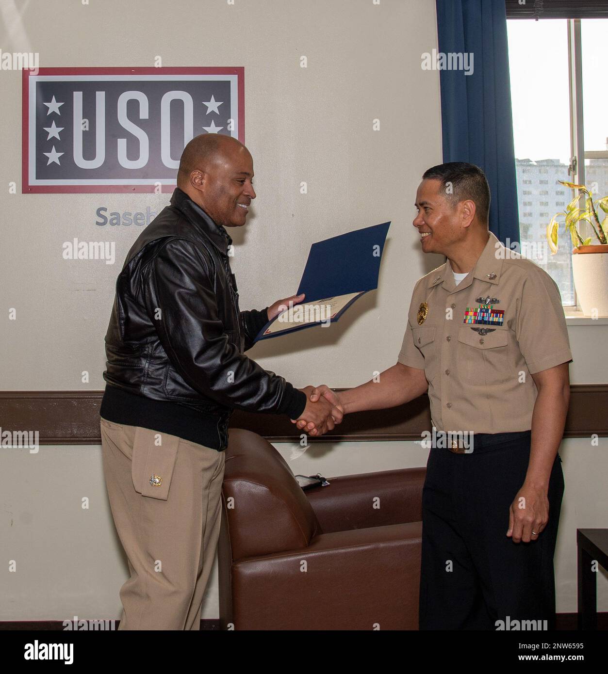 Capt. David Adams, Commander, Fleet Activities Sasebo (CFAS), presents ...